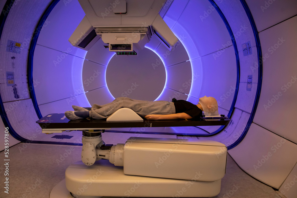 Radiation proton therapy. Brain cancer child patient lying on ...