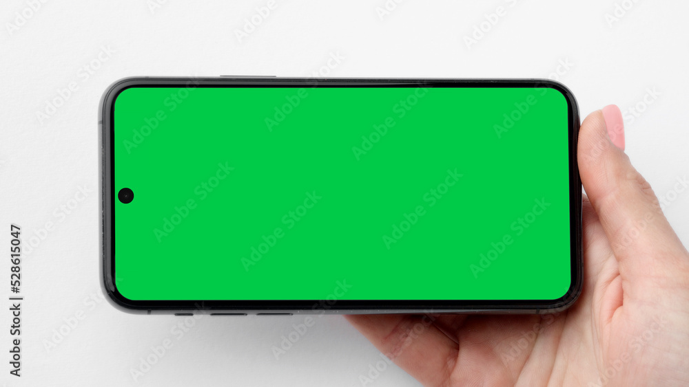 Hand holding smartphone. Hand holding green screen smartphone. Green ...