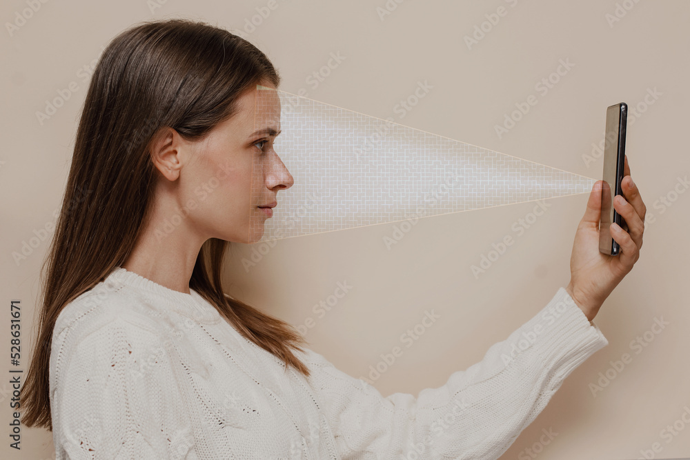 Caucasian woman scans her face using facial recognition system on her ...