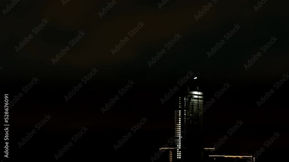 BUILDING CONSTRUCTION AT NIGHT. Isolated. With a working crane on the ...