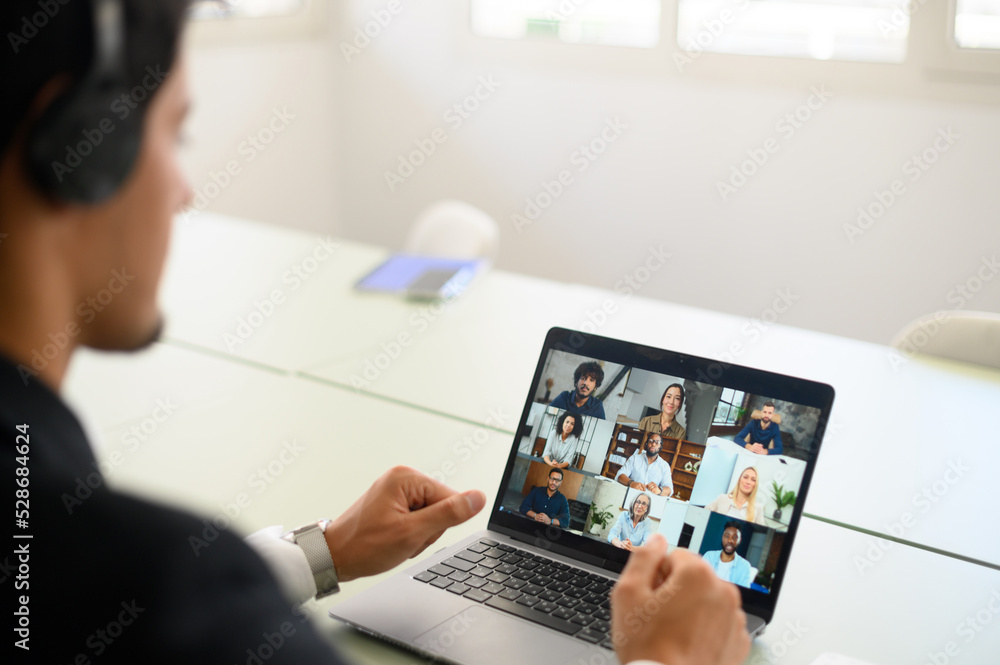 Latin businessman using laptop for video communication with diverse ...