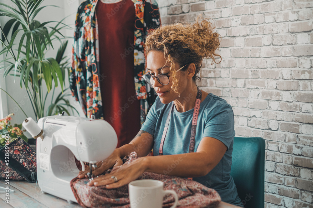 One worker woman at home or workshop using and working with sewing ...