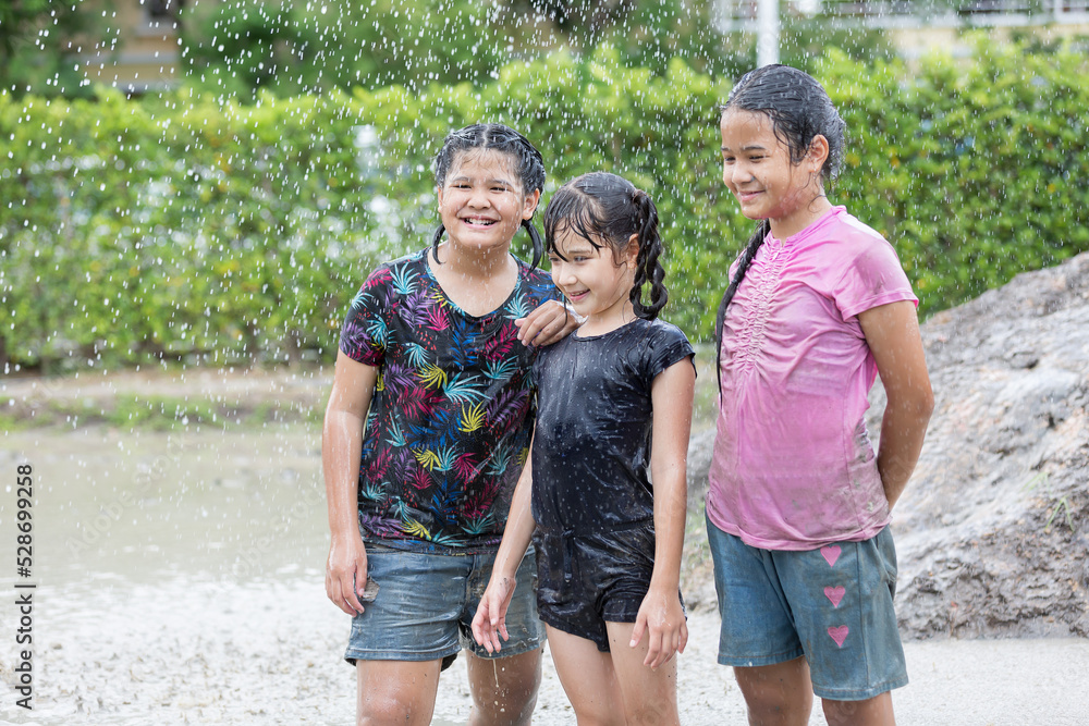 Group of happy children girl playing in wet mud puddle during raining ...