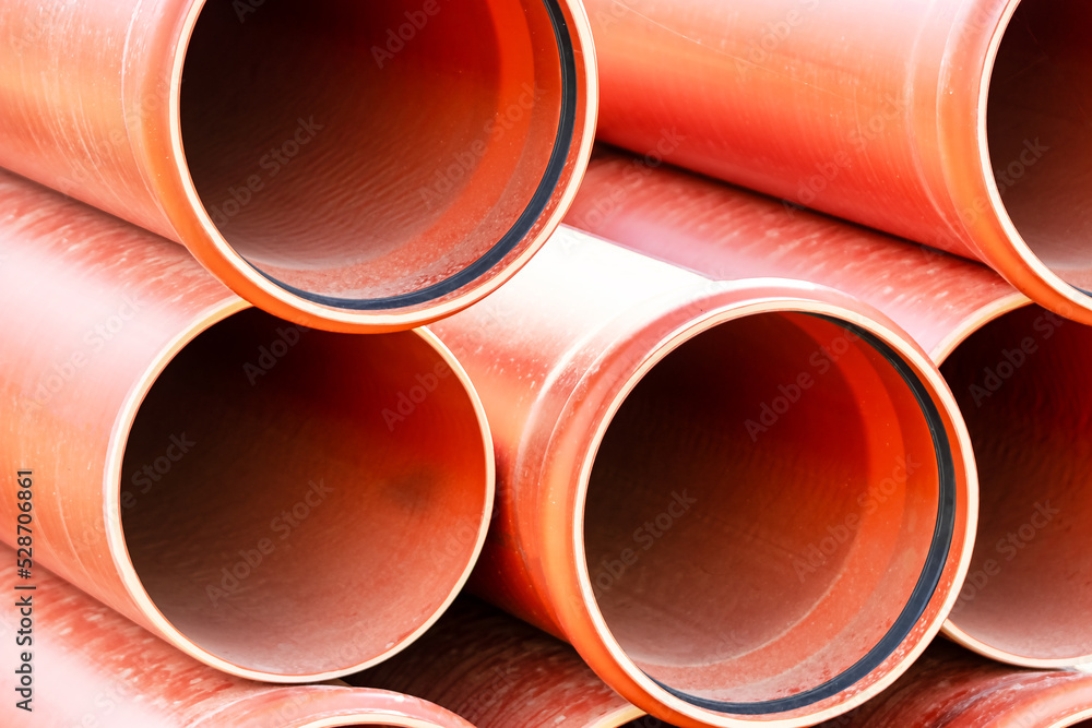 Orange sewer pipes at the construction site. Preparation for the ...