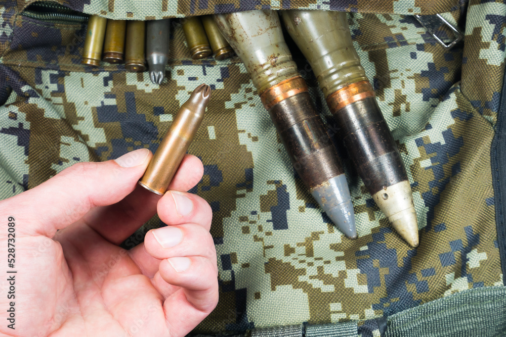 Soldier hold Bullets, shells, cartridges and projectiles on khaki ...