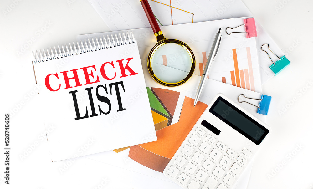 White notepad text CHECK LIST with diagram,chart,calculator on the ...