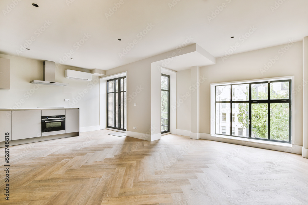Interior of empty white kitchen with windows and wooden parquet floor ...