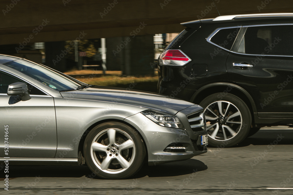 Side view of the front of the car. Cars drive along the street in heavy ...