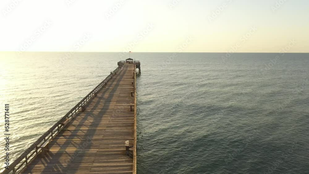 Fishing pier in early morning sun at coastal vacation destination ...