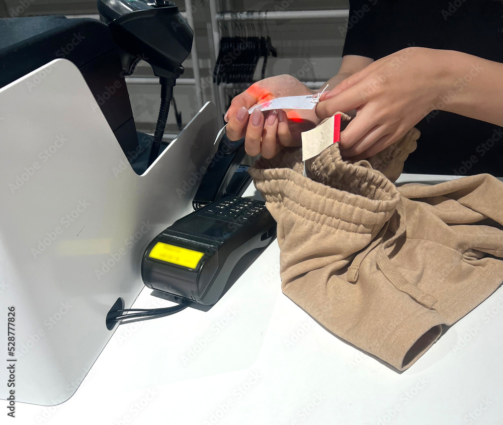 buying clothes. label scanning. cashier scans the barcode on the ...