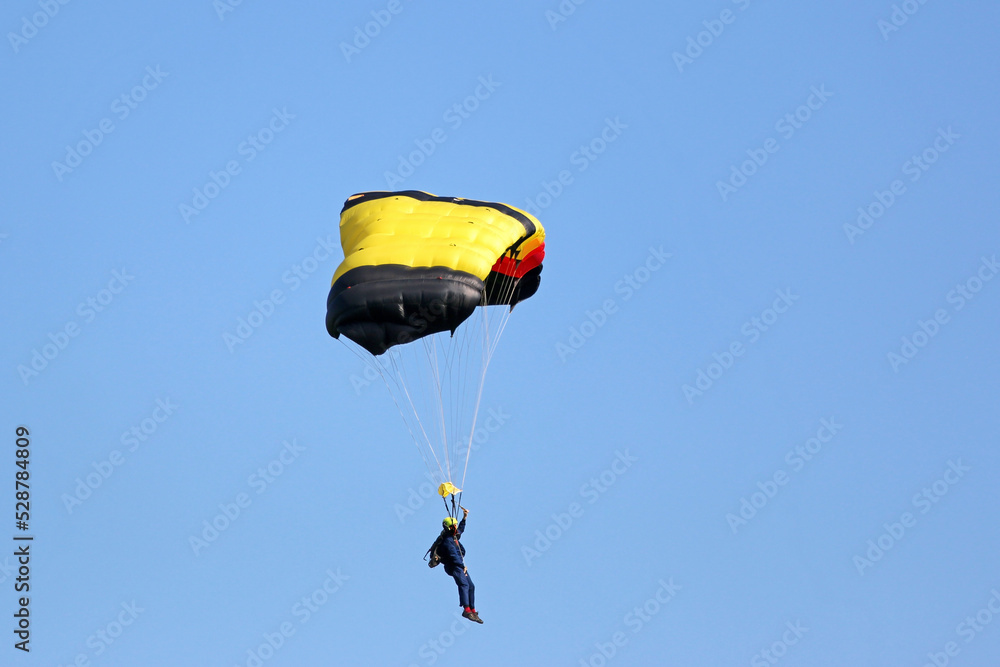 Skydiver flying wing in a blue sky Stock Photo | Adobe Stock