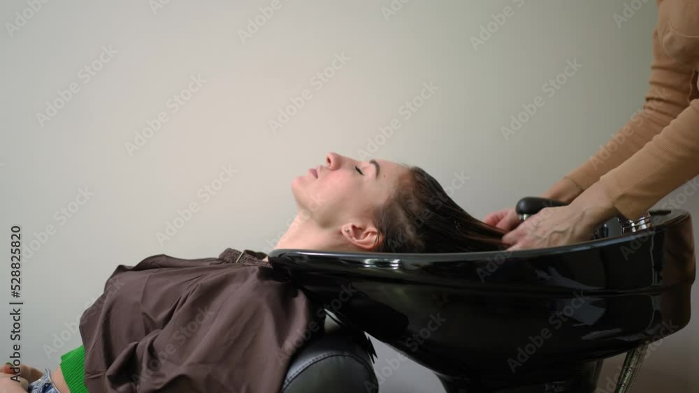 Vidéo Stock Side view Caucasian young woman lying down on hair washing ...