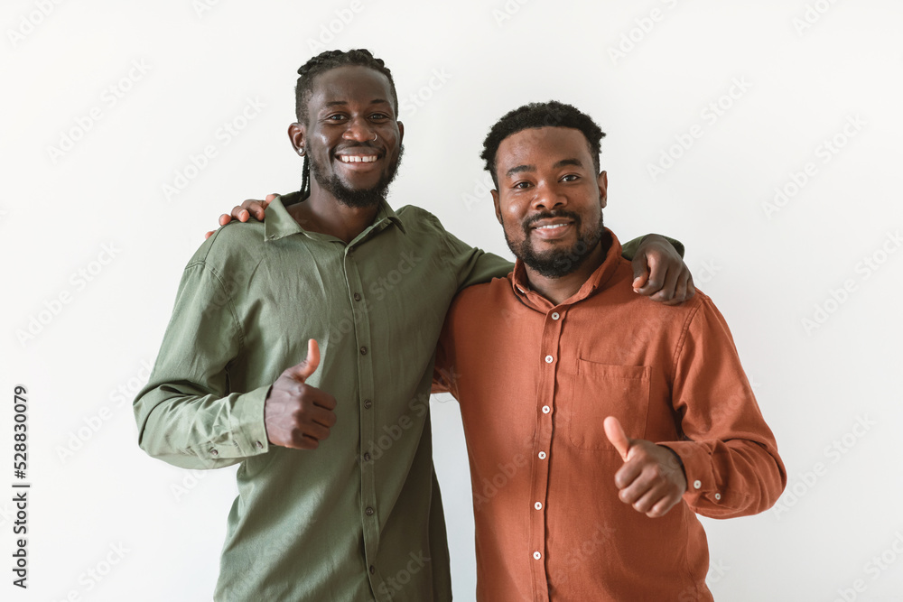 Two Black Men Gesturing Thumbs Up Embracing Over White Background Stock ...