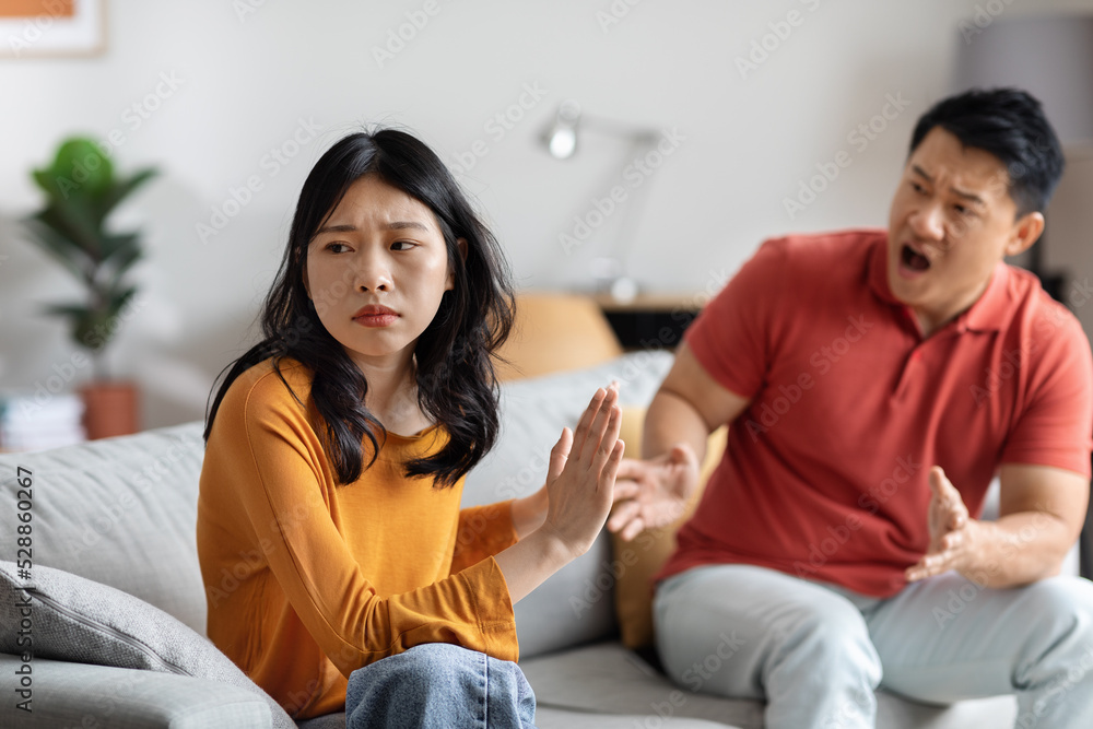 Angry asian husband yelling at his upset wife Stock Photo | Adobe Stock