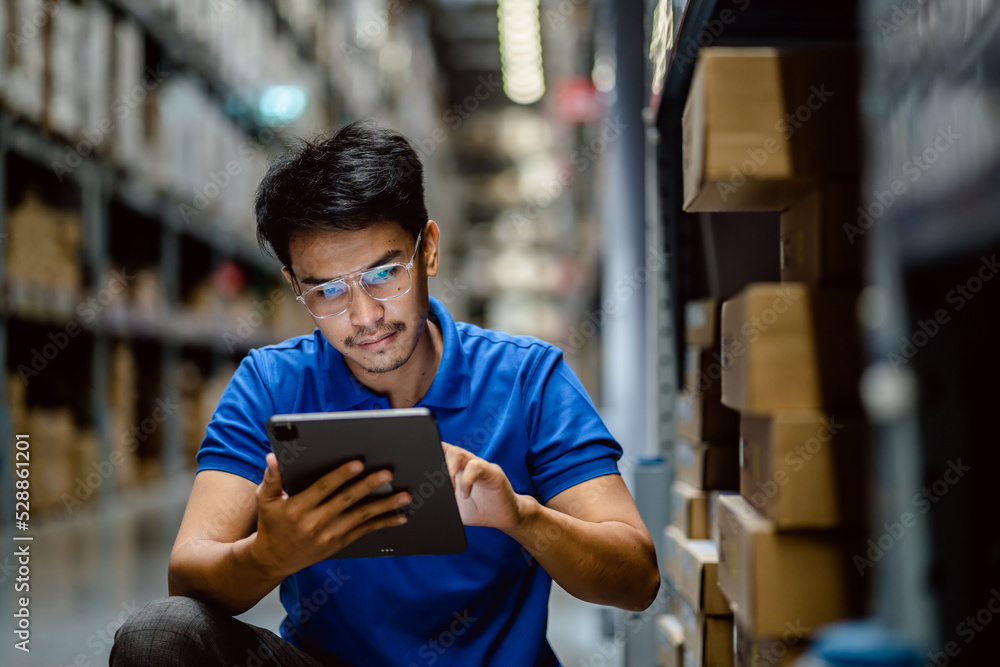 Warehouse Worker using digital tablets to check the stock inventory on ...