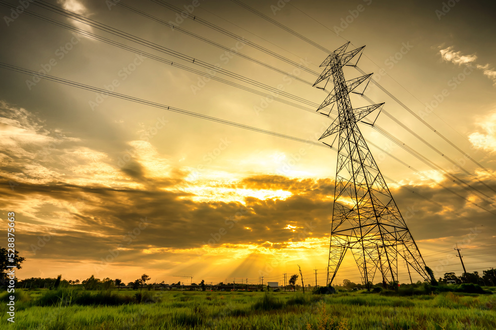 high voltage power poles set in natural grass field sunset background ...