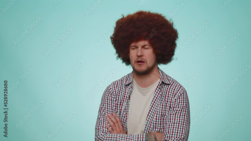 Cheerful funny man with lush hairstyle showing tongue making faces at ...