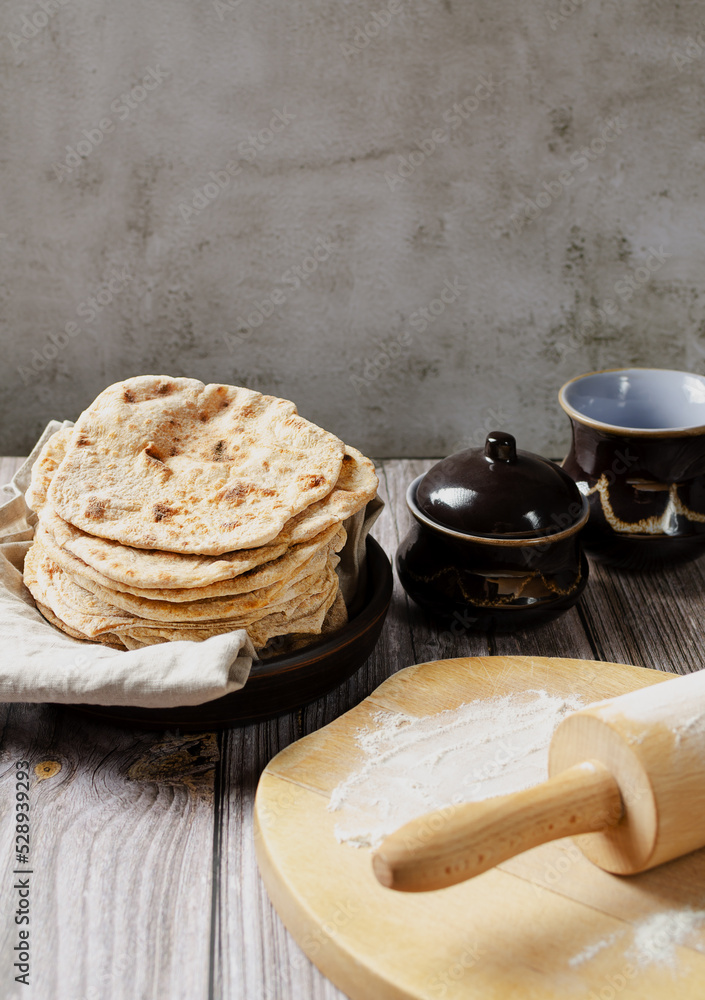 Homemade Chapati Roti Flatbread with rolling pin and flour on grey ...