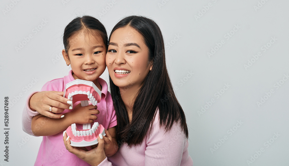 Korean mom teaching little girl how to properly care for her teeth ...