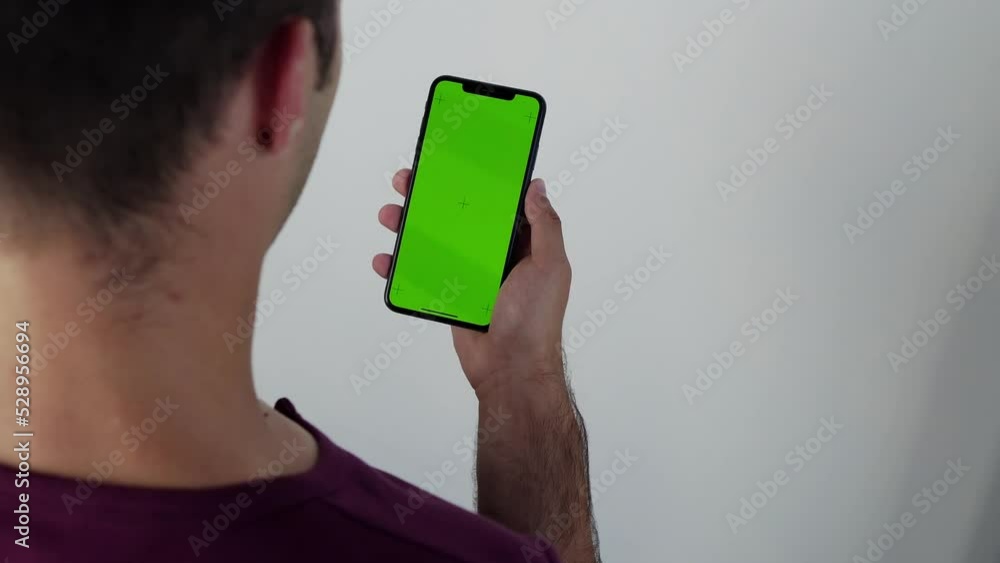 Camera from behind zoom out filming close up male man holding mobile ...