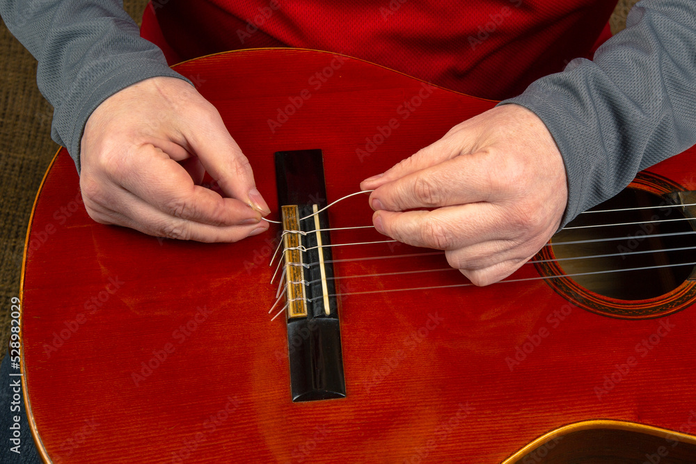 replacement and insertion of nylon strings in a classical guitar ...
