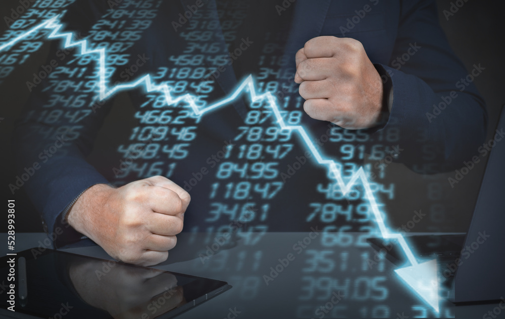 furious businessman clenching his fists looking at graph of declining ...