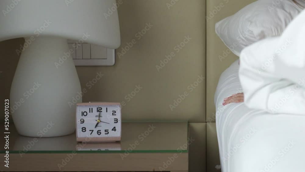 Woman Turns Off Ringing Alarm Clock On Bedside Table After Waking Up In