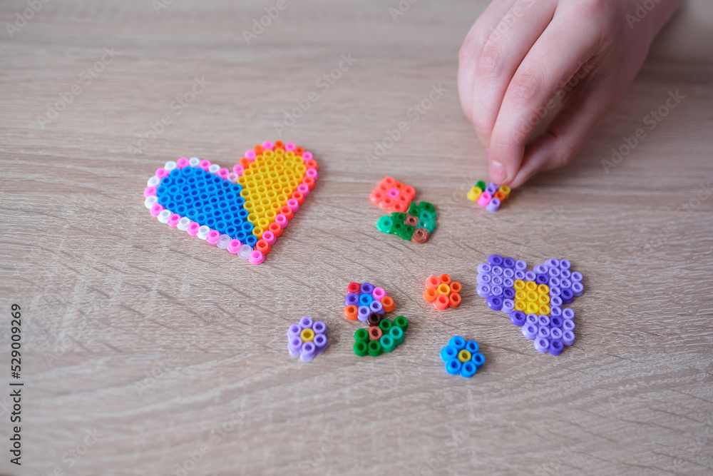 close-up of heart, children's hands creating perler bead patterns, make ...
