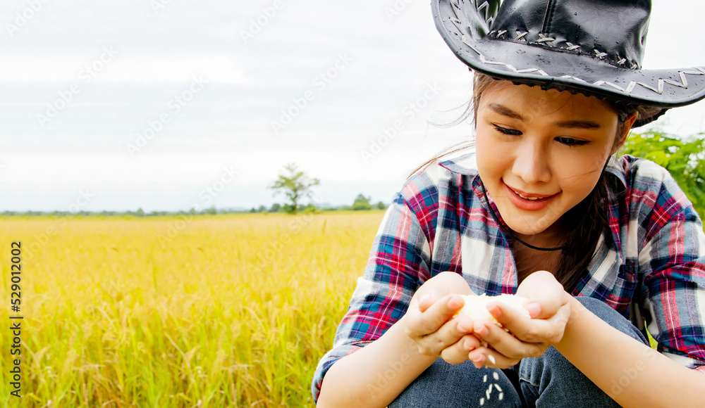 Happy beautiful asian woman farmer sitting in rice field looking at ...
