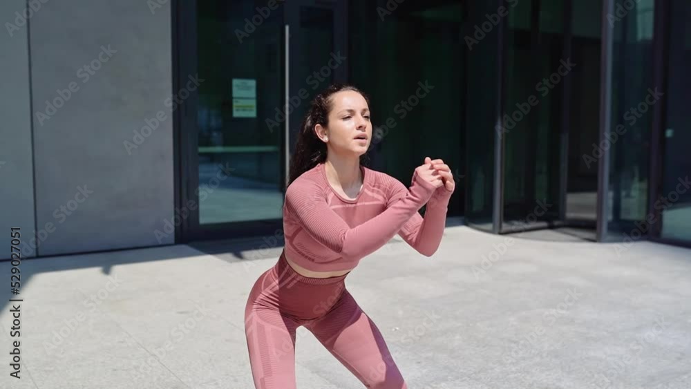 Sweaty fit young woman doing squats during outdoor fitness training ...