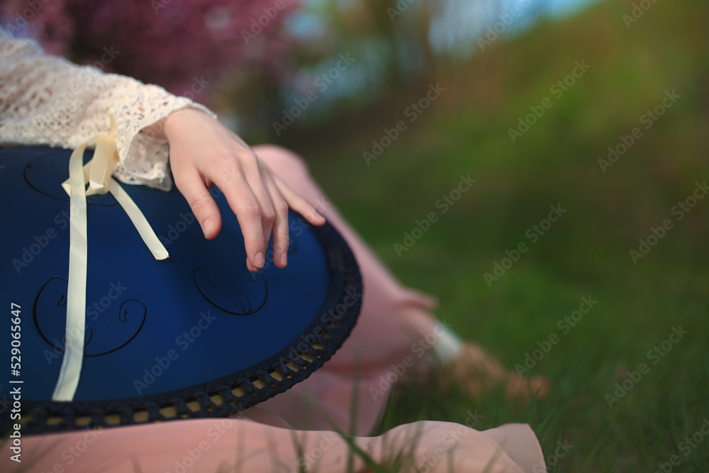 Female hand playing a tongue drum musical instrument (metal drum with ...