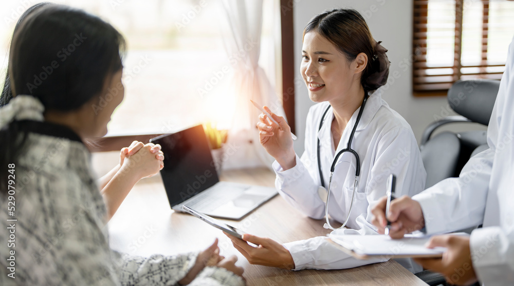 Doctor and patient are discussing at clinic. Young asian female doctor ...