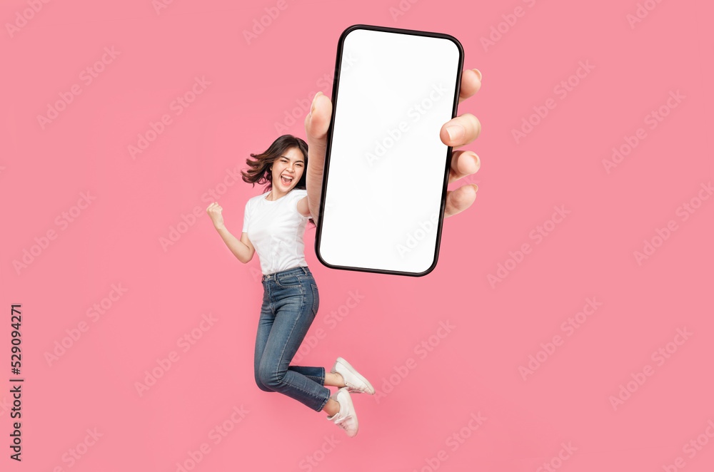Full length of cheerful Asian woman jumping and smiling in air with ...