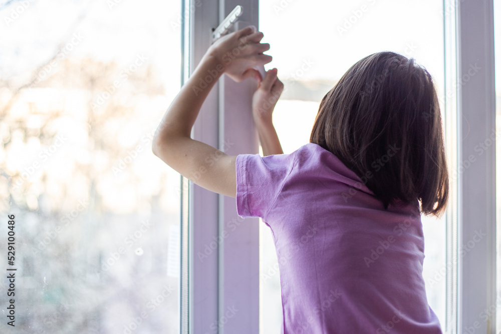Child closes the window. Dangerous and safety. Stock Photo | Adobe Stock
