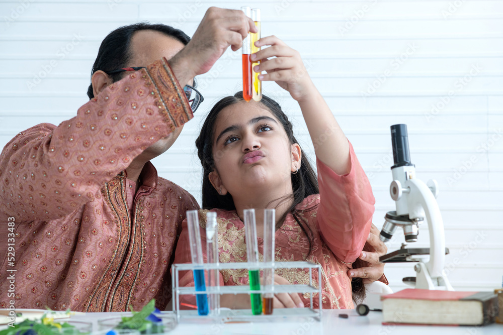 Indian or Pakistan father or teacher and little child girl wears ...