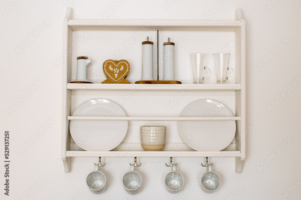 White cups hanging from a white wall rack. Small kitchenette, kitchen ...