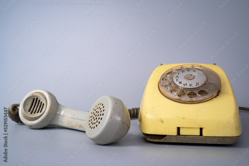 Old dirty yellow rotary telephone with gray removed phone receiver on ...