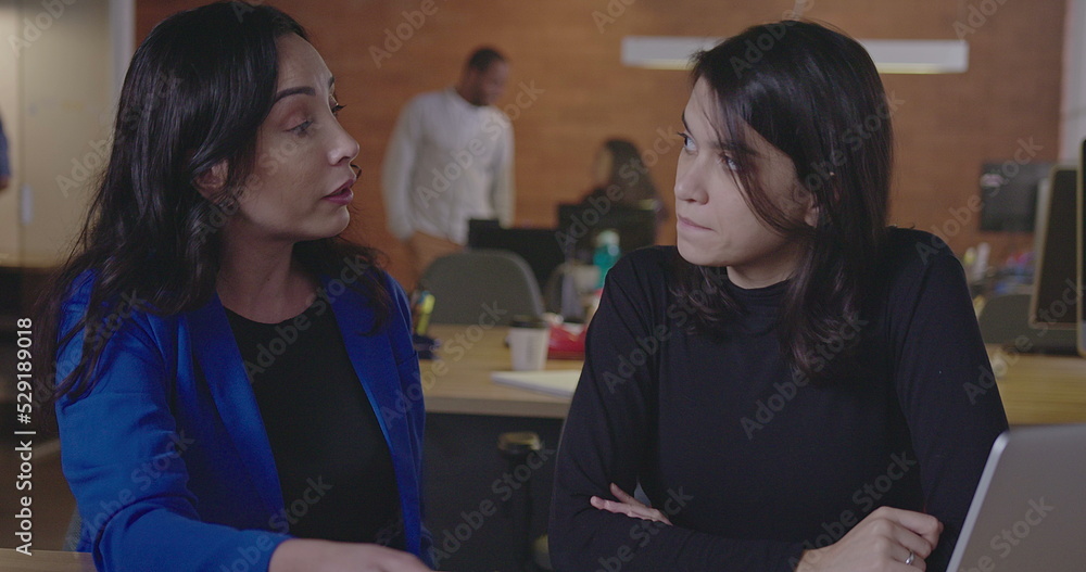 Two female employees working at night in the office. Modern workplace ...