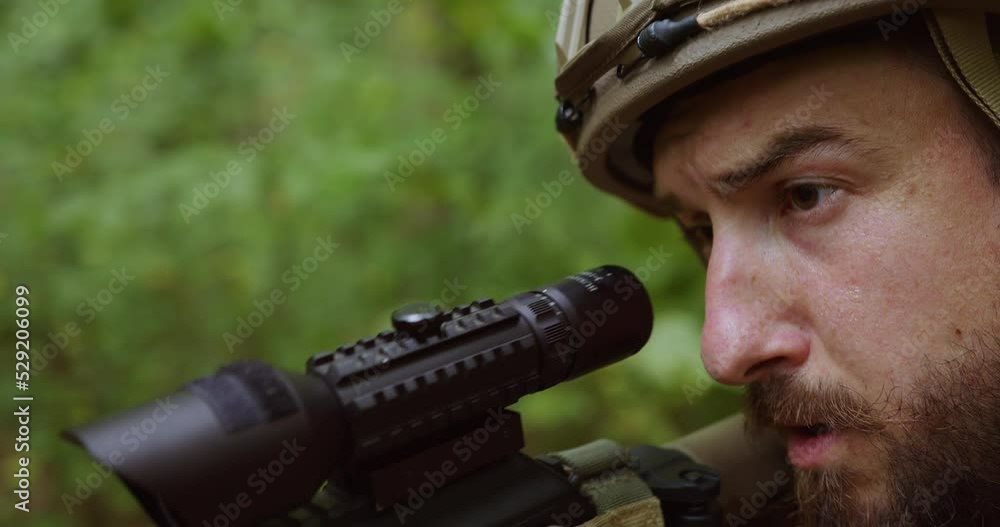 the soldier talks, aims at the sight of the rifle, lowers the weapon ...