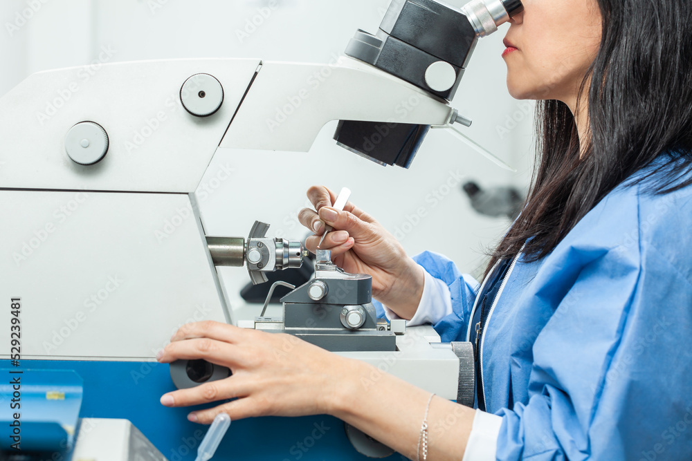 Female scientist placing a sample on a transmission electron microscopy ...