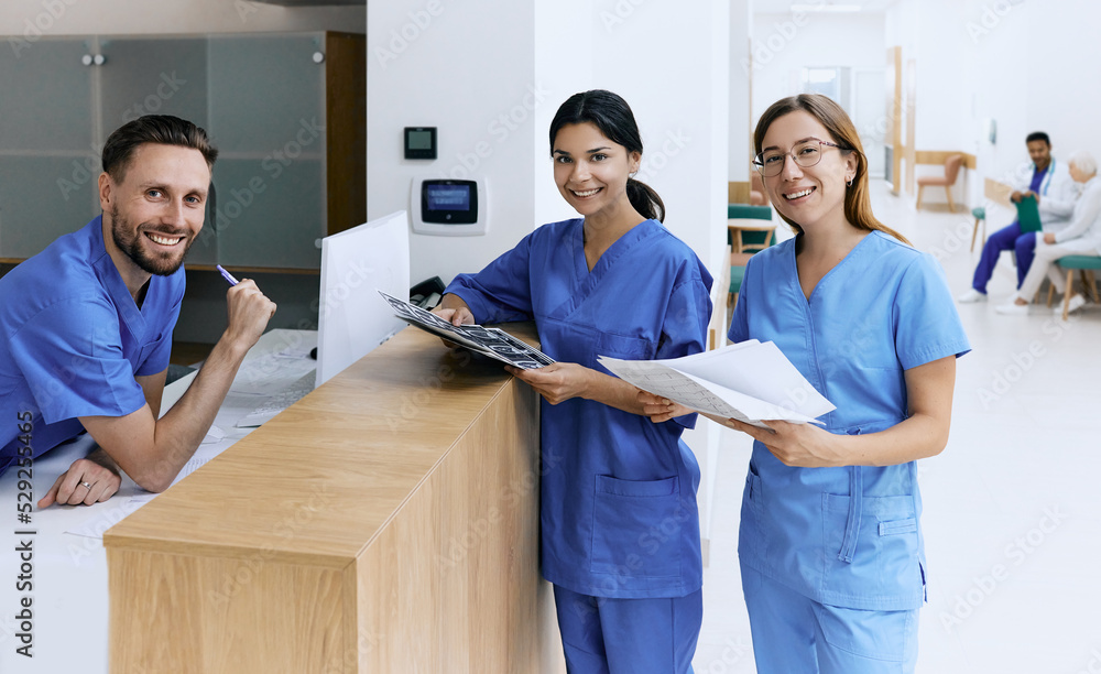 Nurse on duty talking with medical assistants during working day in ...