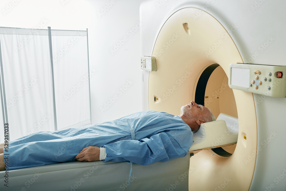 Mature patient going into CT scanner during computed tomography in ...