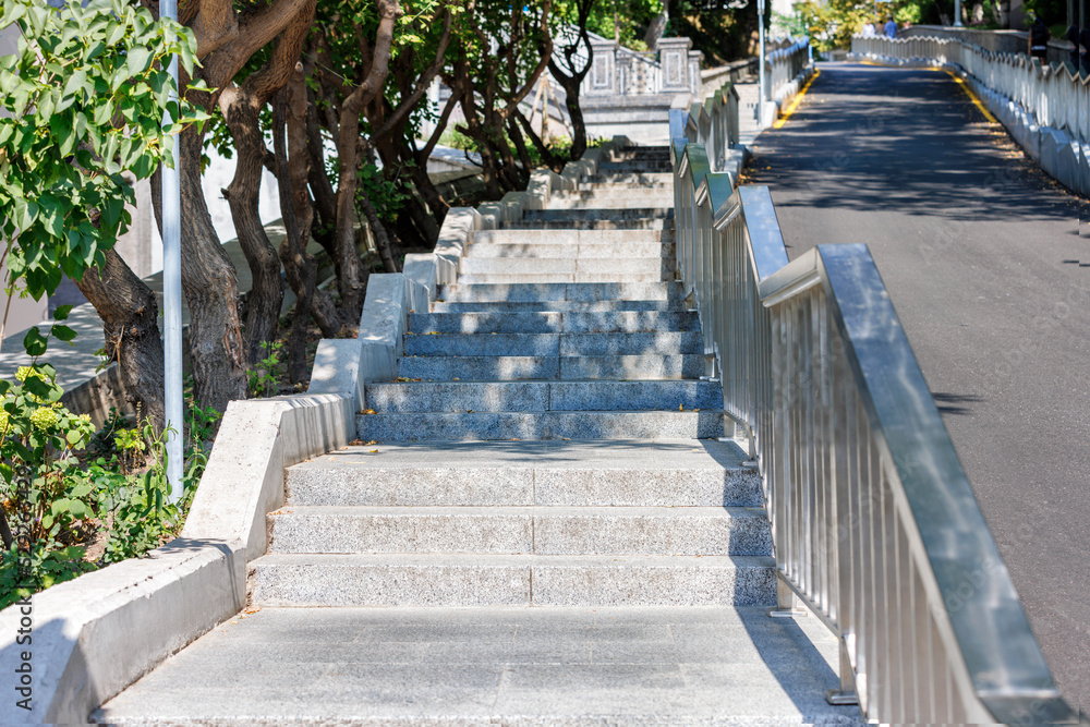Stone pedestrian stairs along the asphalt road in the modern ...