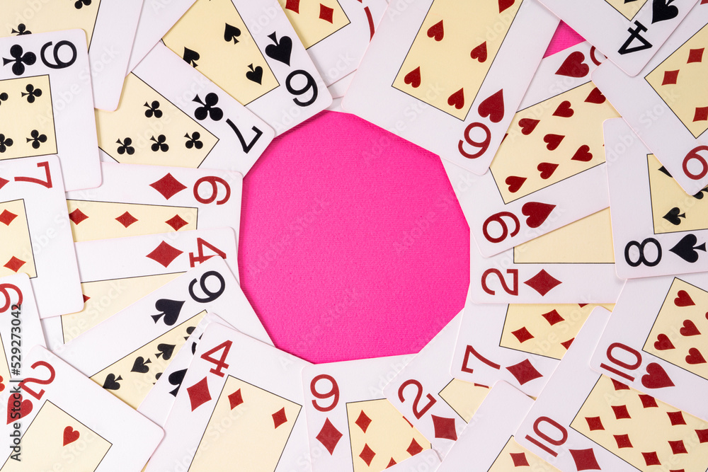 A deck of playing cards laid out in a circle with copy space or ...