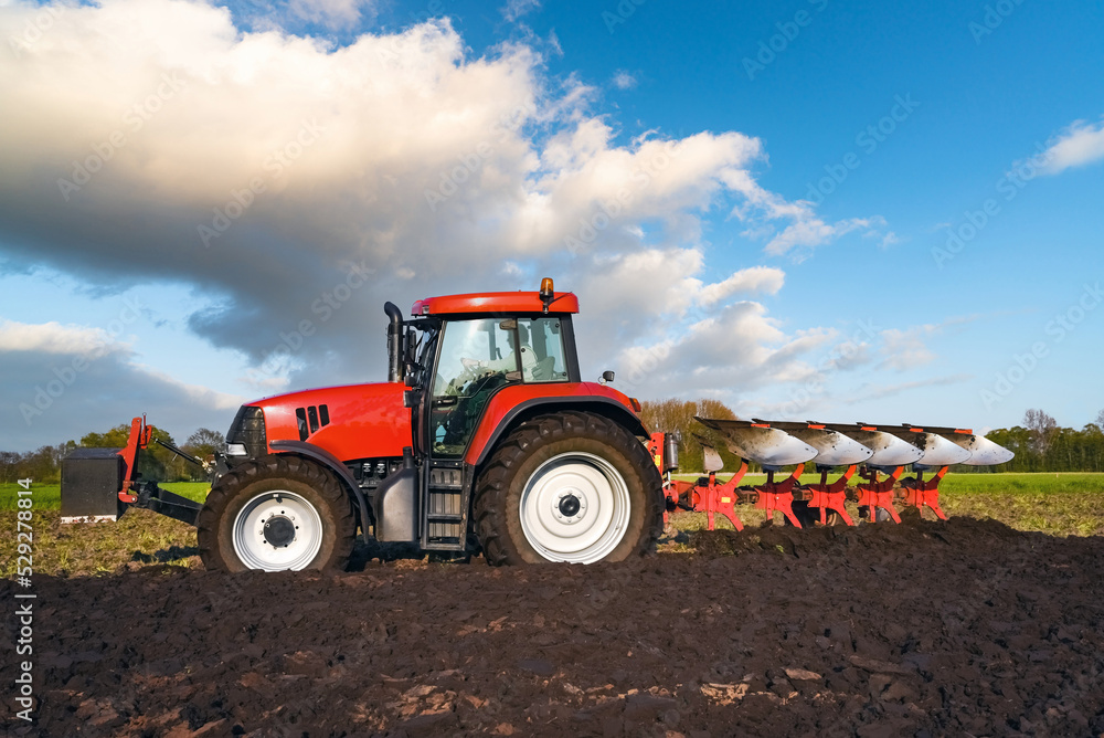 Roter Traktor mit Pflug, beim pflügen eines Feldes. Stock Photo | Adobe ...