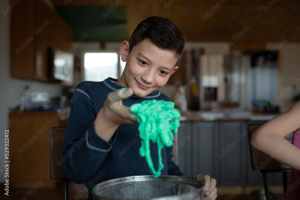 Tween boy holding up the slime he created Stock Photo | Adobe Stock