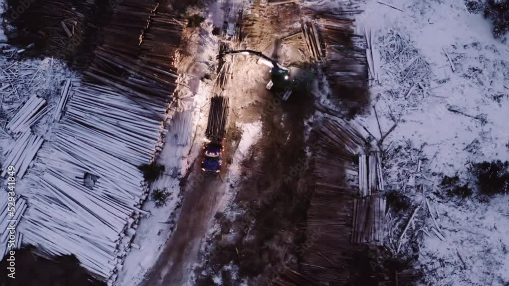Dramatic top down close up aerial shot of timber manipulator loading ...