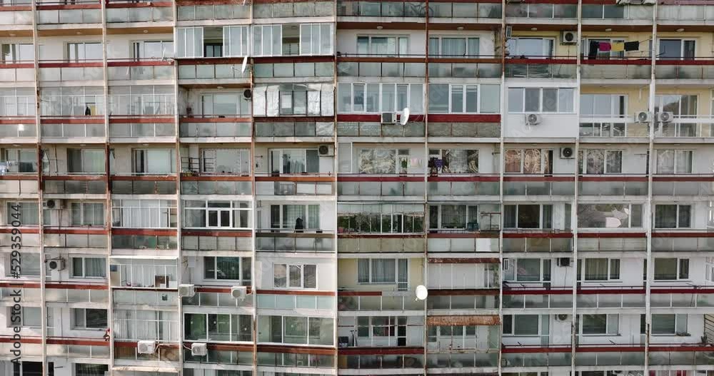 Windows and balconies of an apartment building in winter on sunny day ...