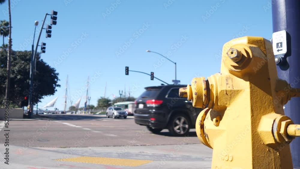 Yellow fire hydrant extinguisher on pavement of San Diego city street ...