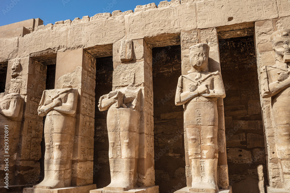 Statues of ancient Egyptian pharaohs and gods. Various hieroglyphs on ...